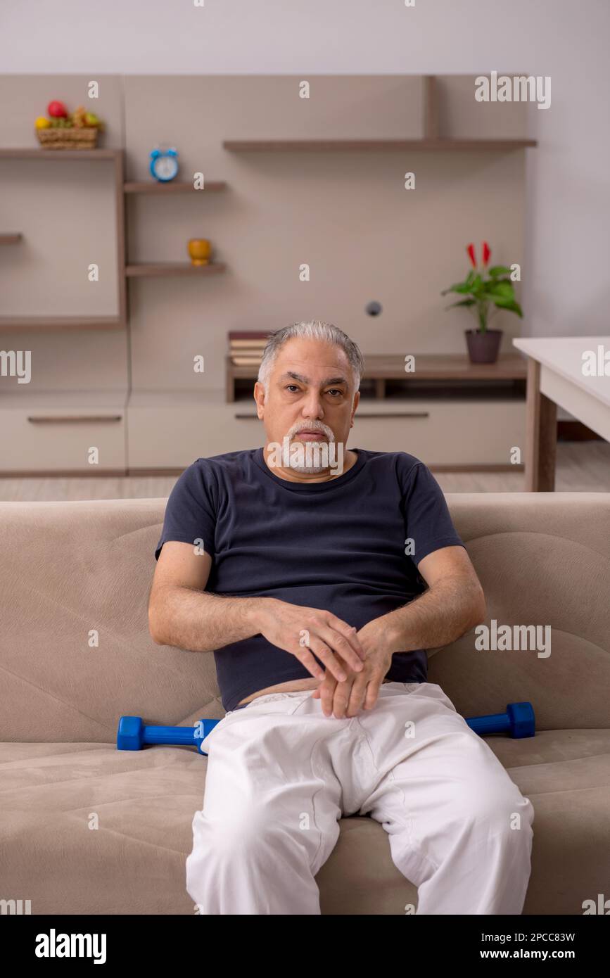 Old man doing sport exercises indoors Stock Photo - Alamy