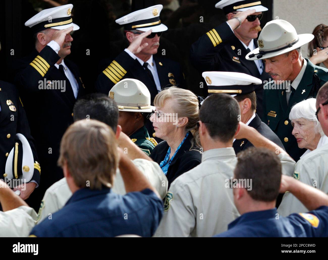 Bonnie McKay, center, is saluted by firefighters while leaving a ...