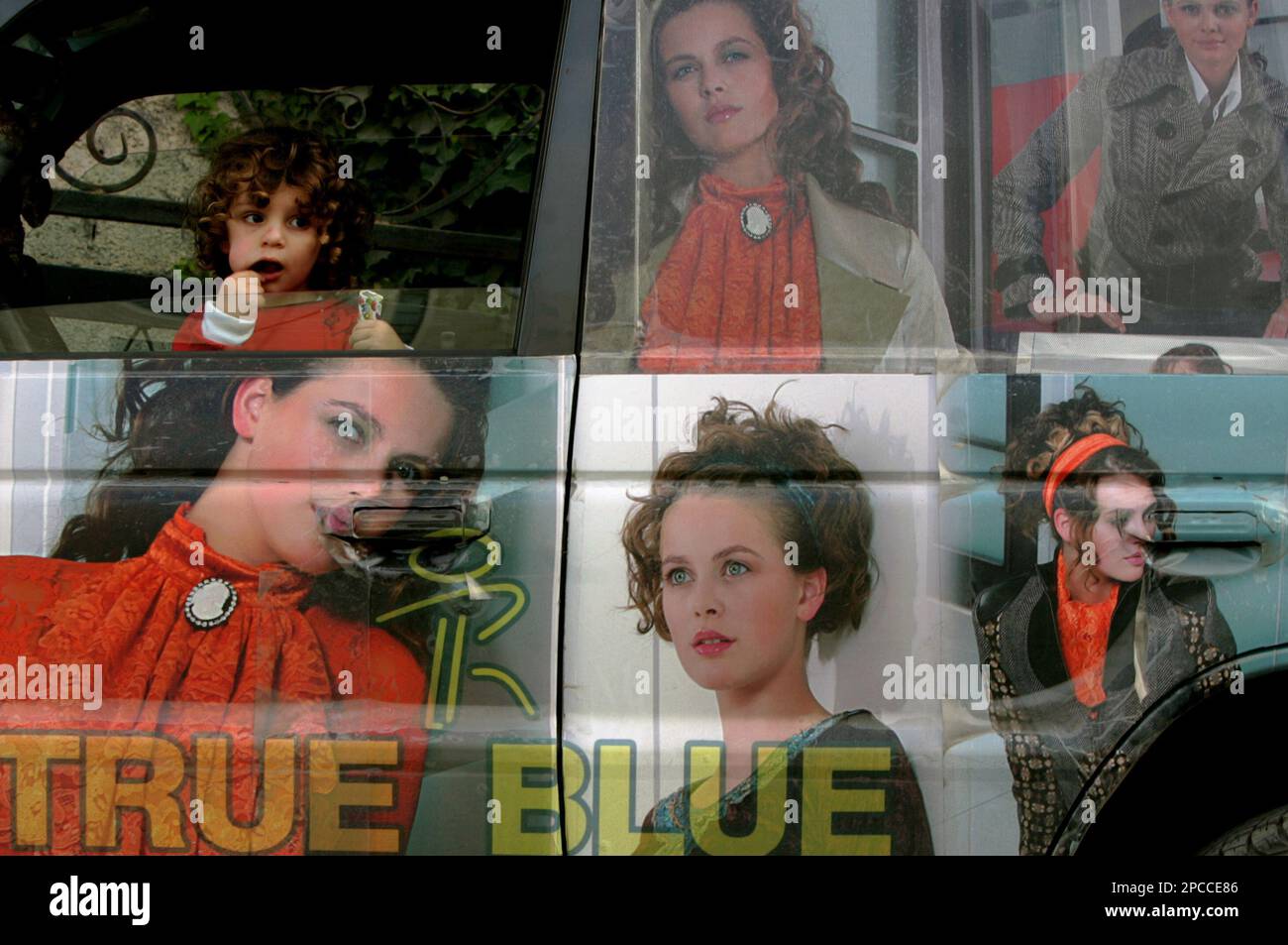 A Palestinian boy looks out a window of a car which is decorated with ...