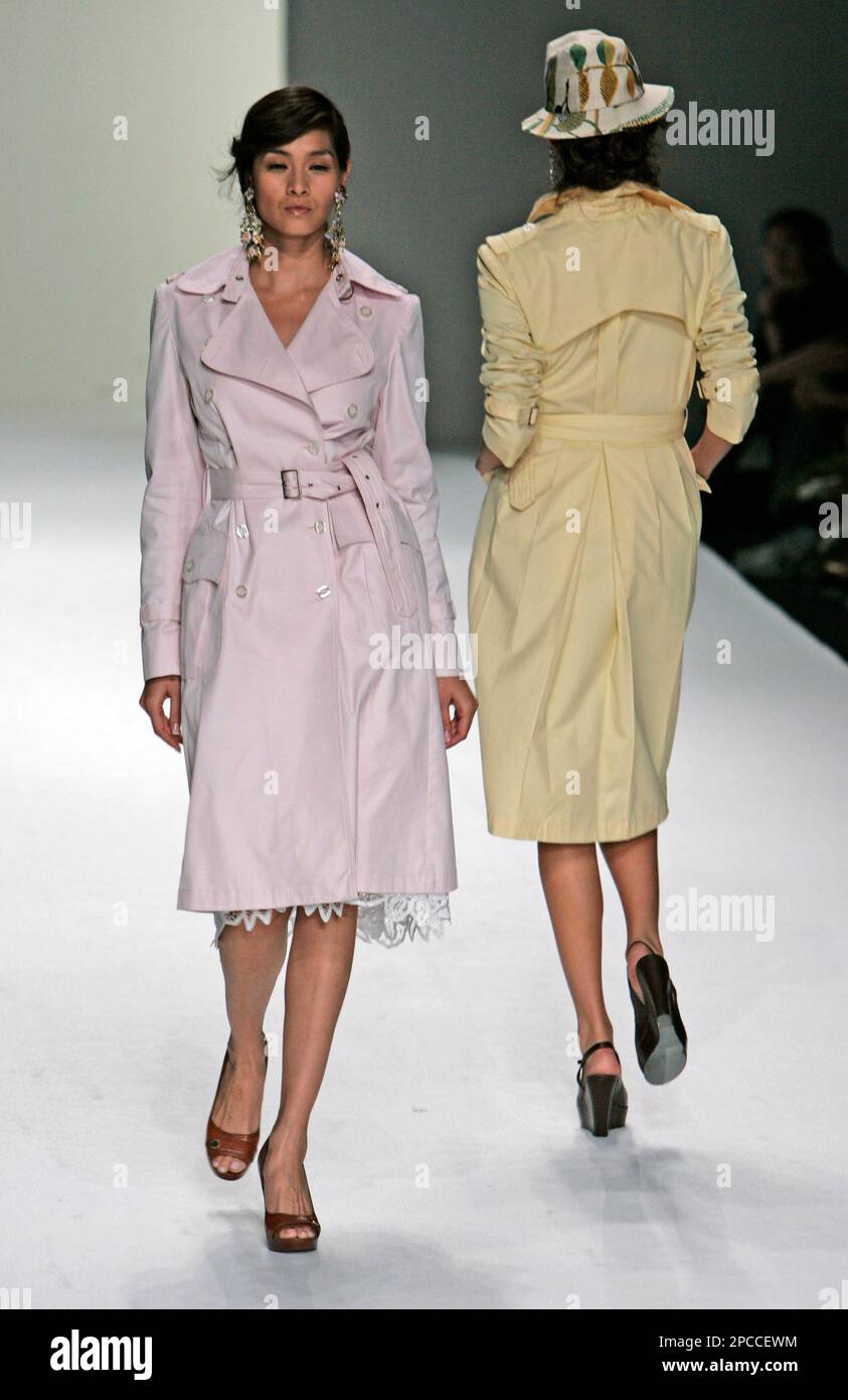 Two models walk on the catwalk showing designs by Thai designer ...