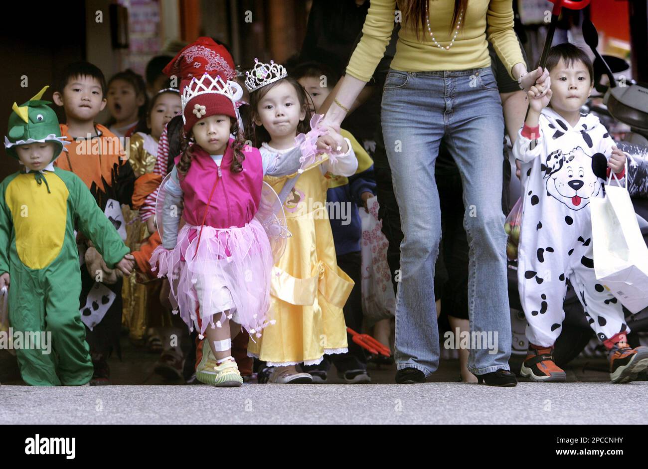 Taiwanese kindergarten pupils dressed in Halloween costumes walk with a ...