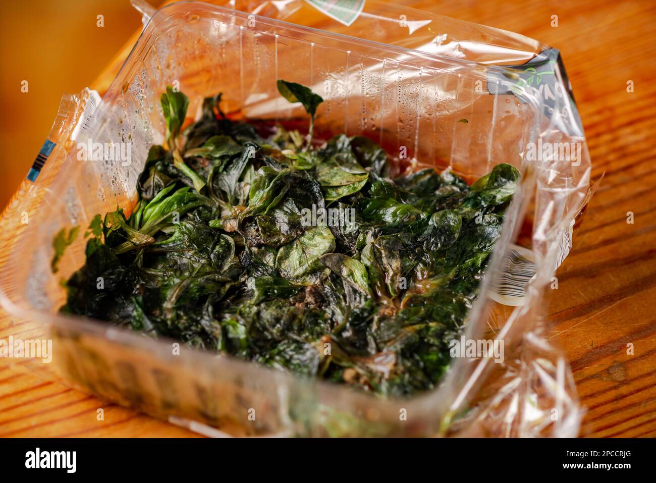 Spoiled mix of different salads in plastic packaging. Expired shelf ...