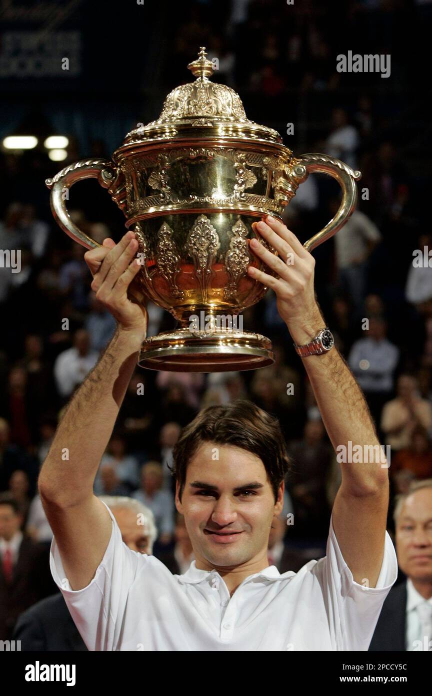 Switzerland's Roger Federer holds up the winner's trophy after his ...
