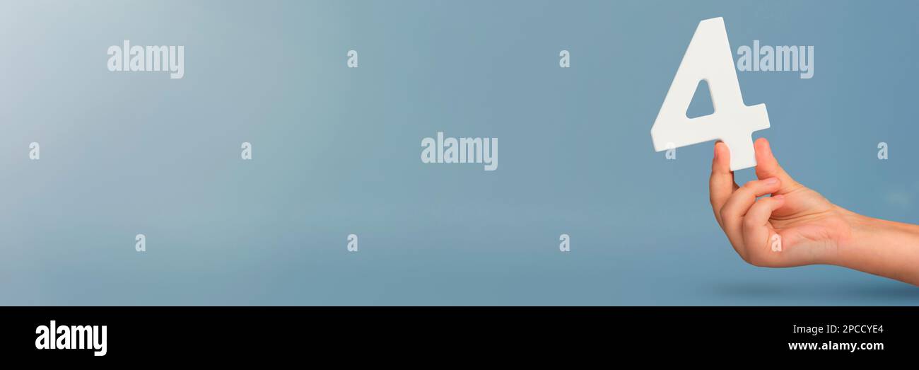 number four in hand. Hand holding white number 4 on blue background ...