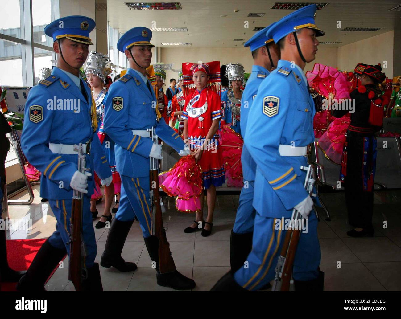 A young girl in a minority costume looks as the Chinese guard of honor ...
