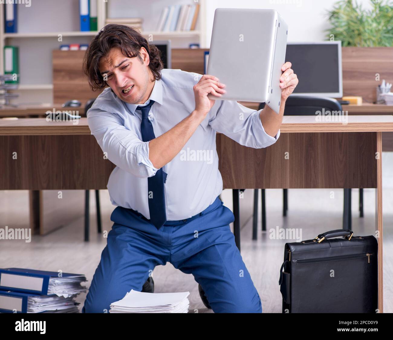 The young male employee and too many work in the office Stock Photo - Alamy