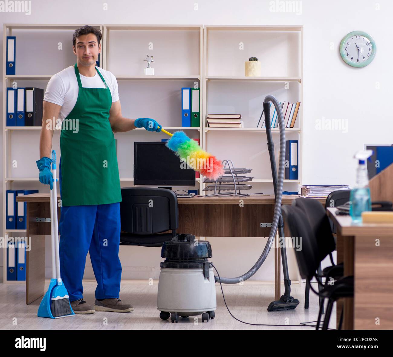 The young handsome contractor cleaning the office Stock Photo - Alamy
