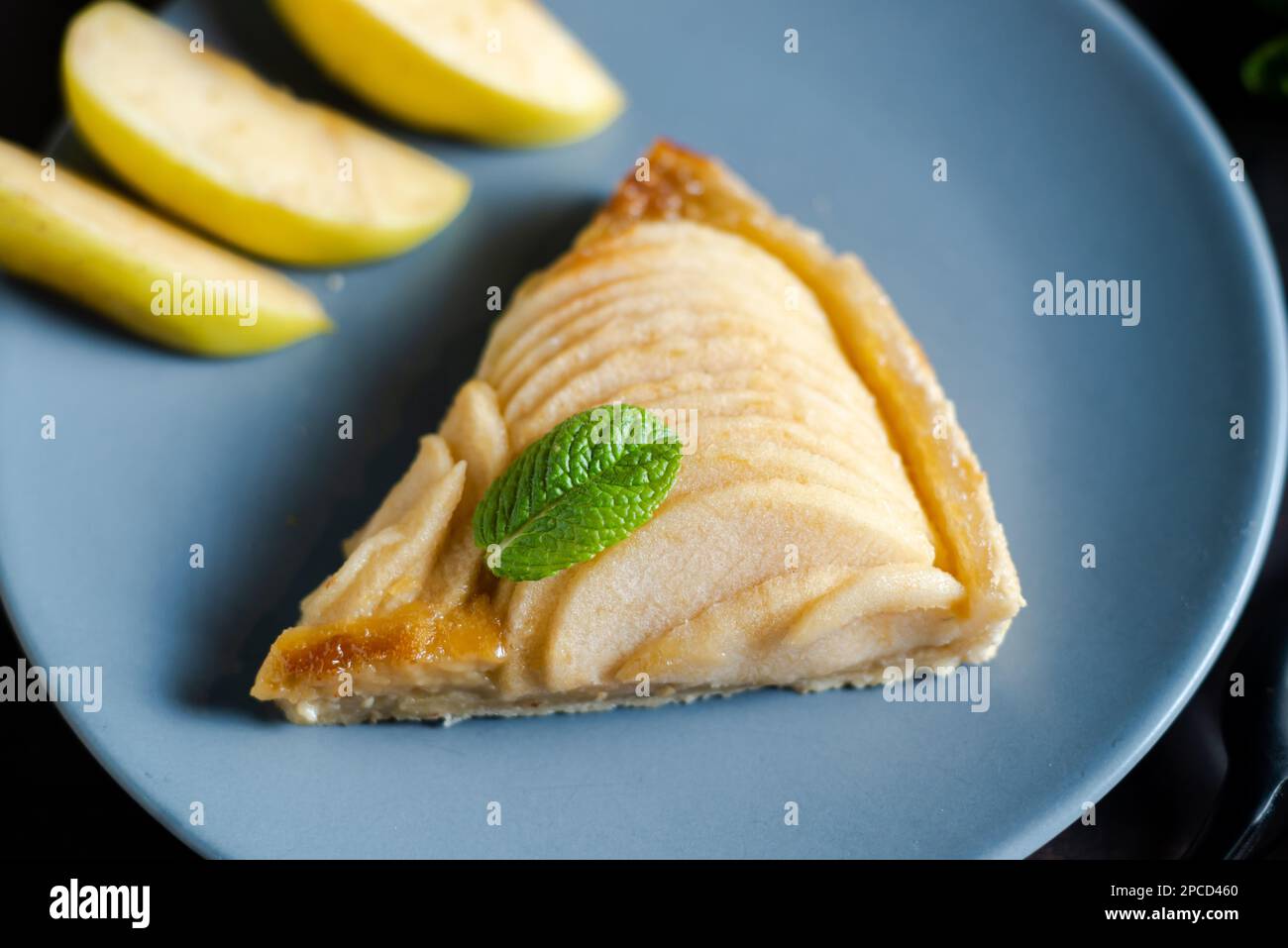 Piece of apple French pie on blue plate looks appetizing and ...