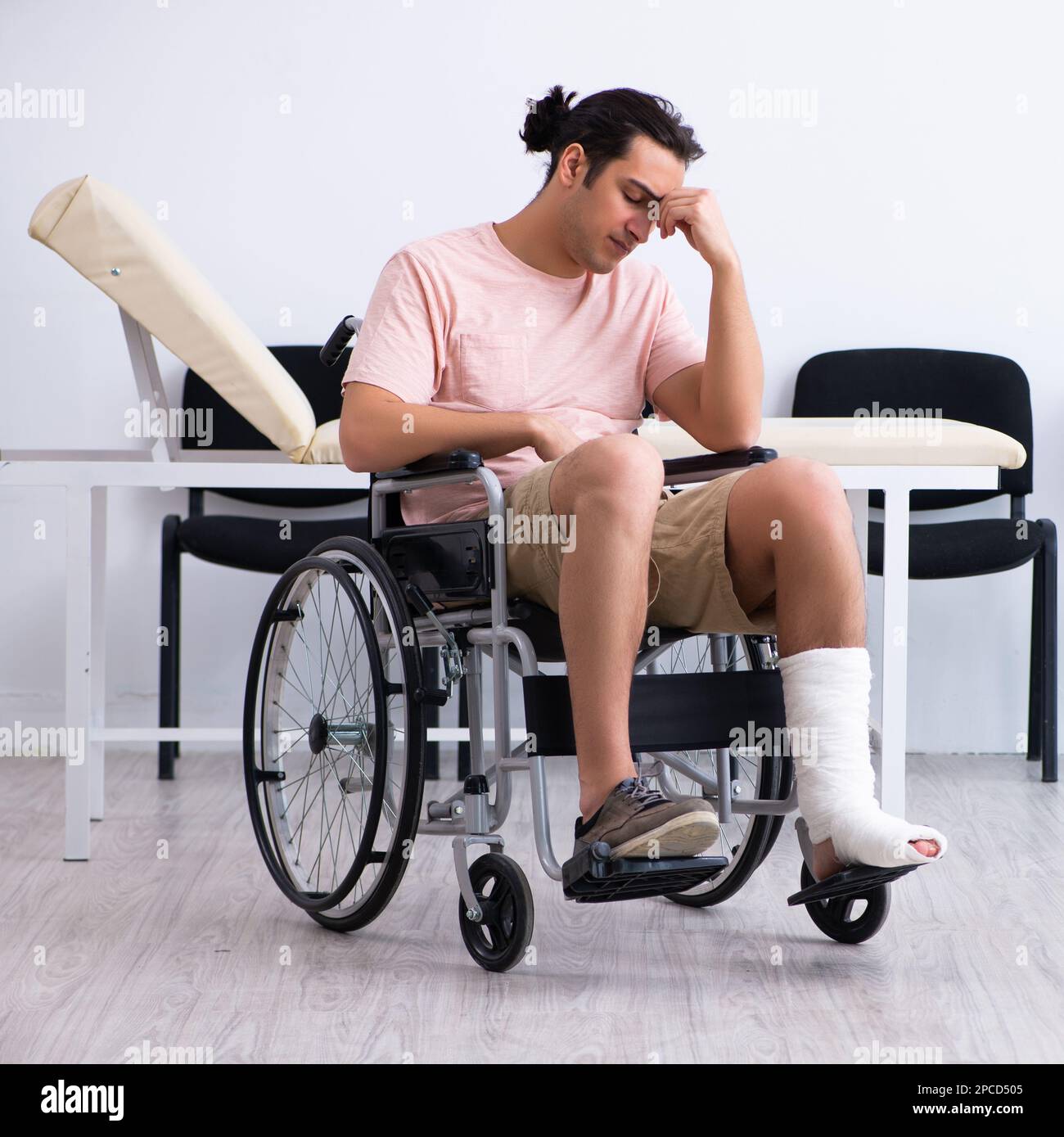The young injured man waiting for his turn in hospital hall Stock Photo ...