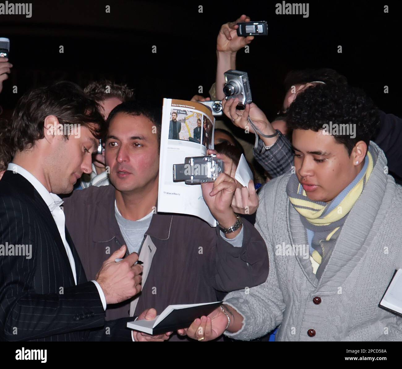British actor Jude signs autographs for his fans, as he arrives for the ...