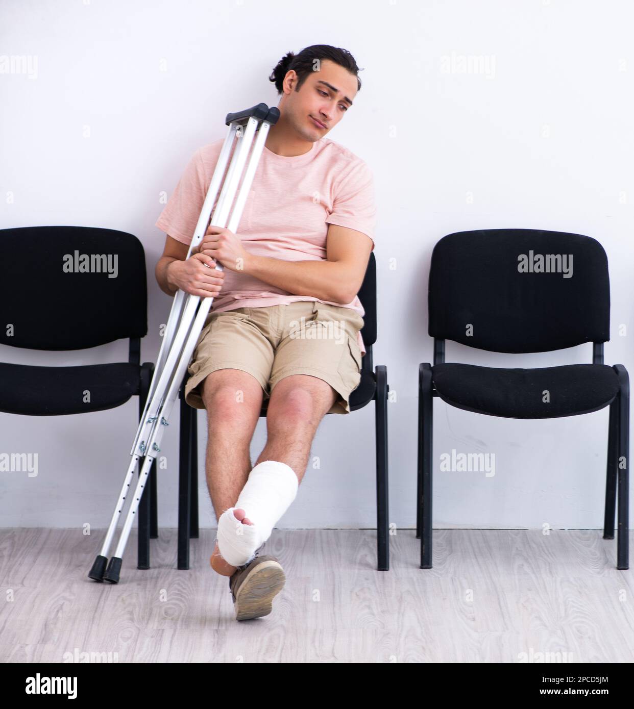 The young injured man waiting for his turn in hospital hall Stock Photo ...