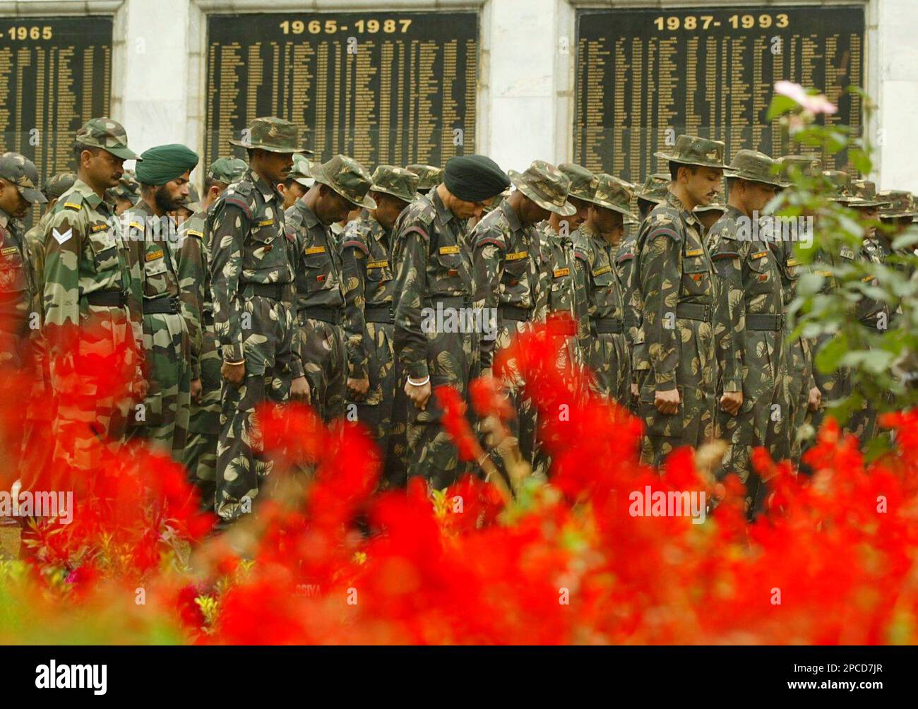 Indian Army soldiers pay homage in front of a wall with names of their ...