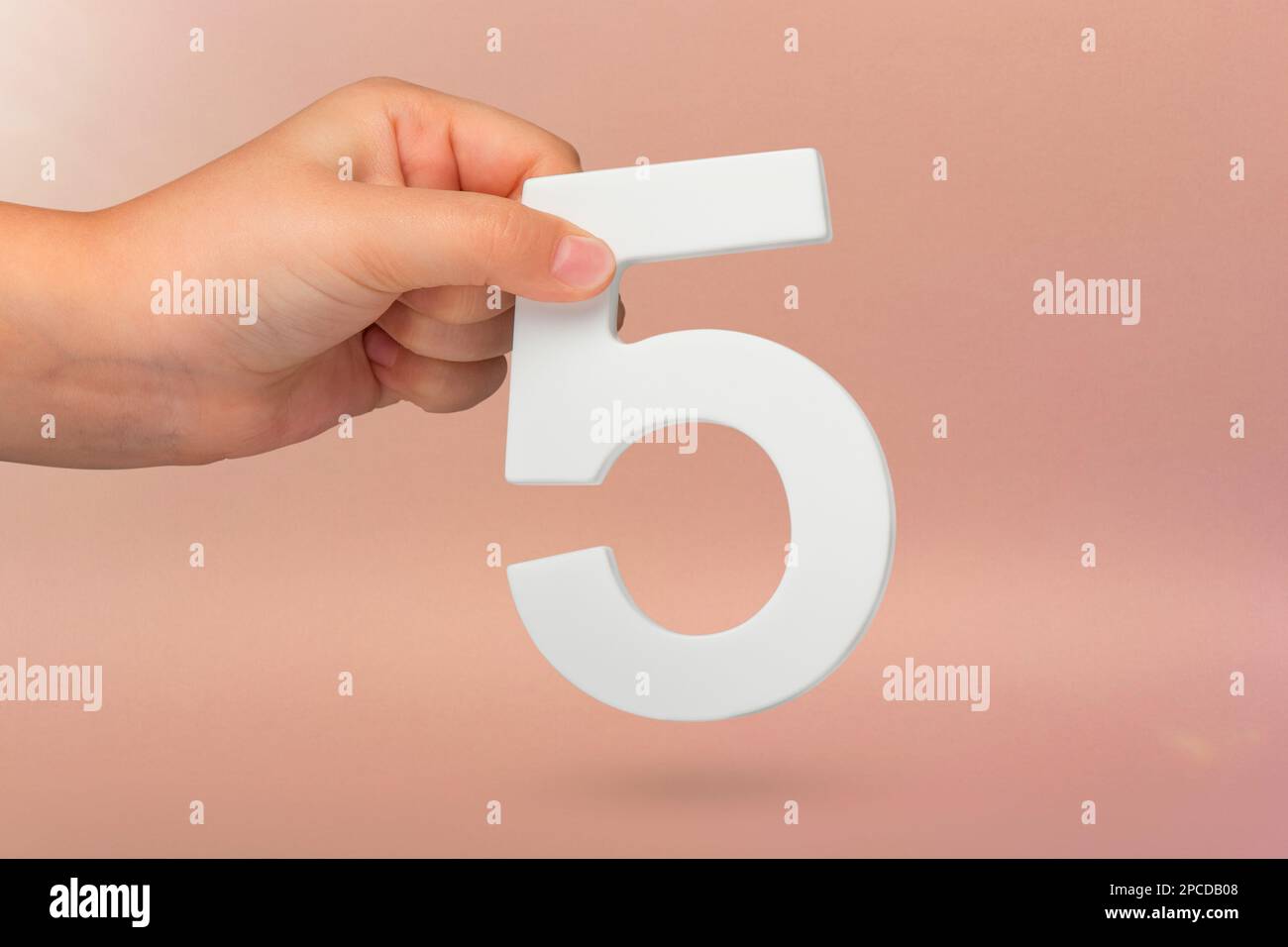 Number five in hand. Hand holding white number 5 on red background with ... Number five in hand. Hand holding white number 5 on red background with ...