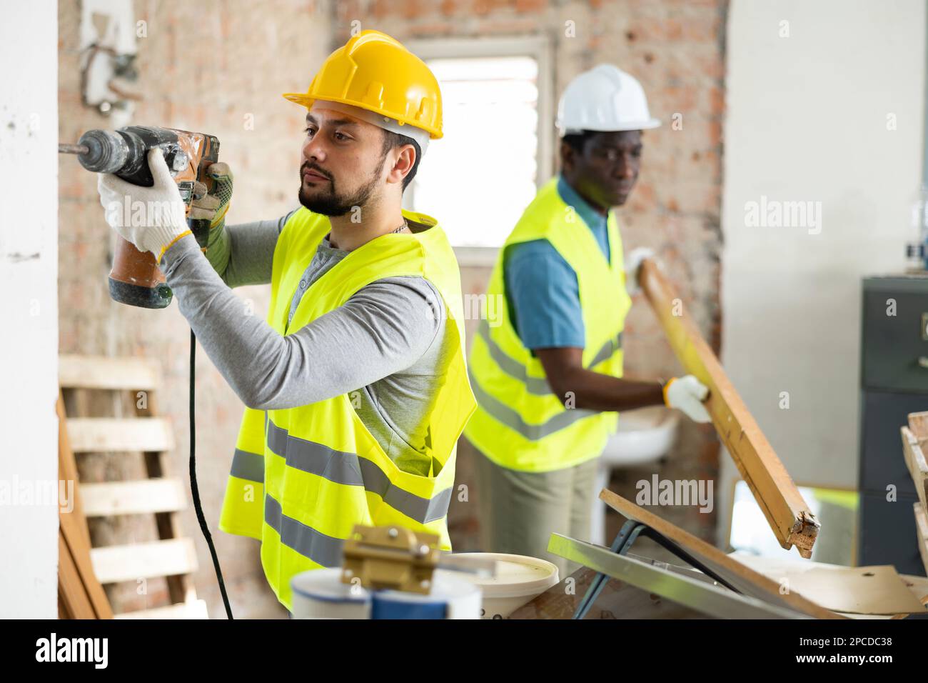 Two builders working on indoor construction site Stock Photo - Alamy