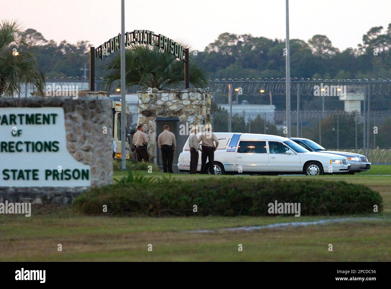 A hearse carrying the body of Danny Rolling passes guards as it drives ...
