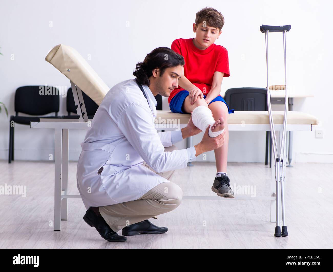 The leg injured boy visiting young doctor traumatologist Stock Photo ...