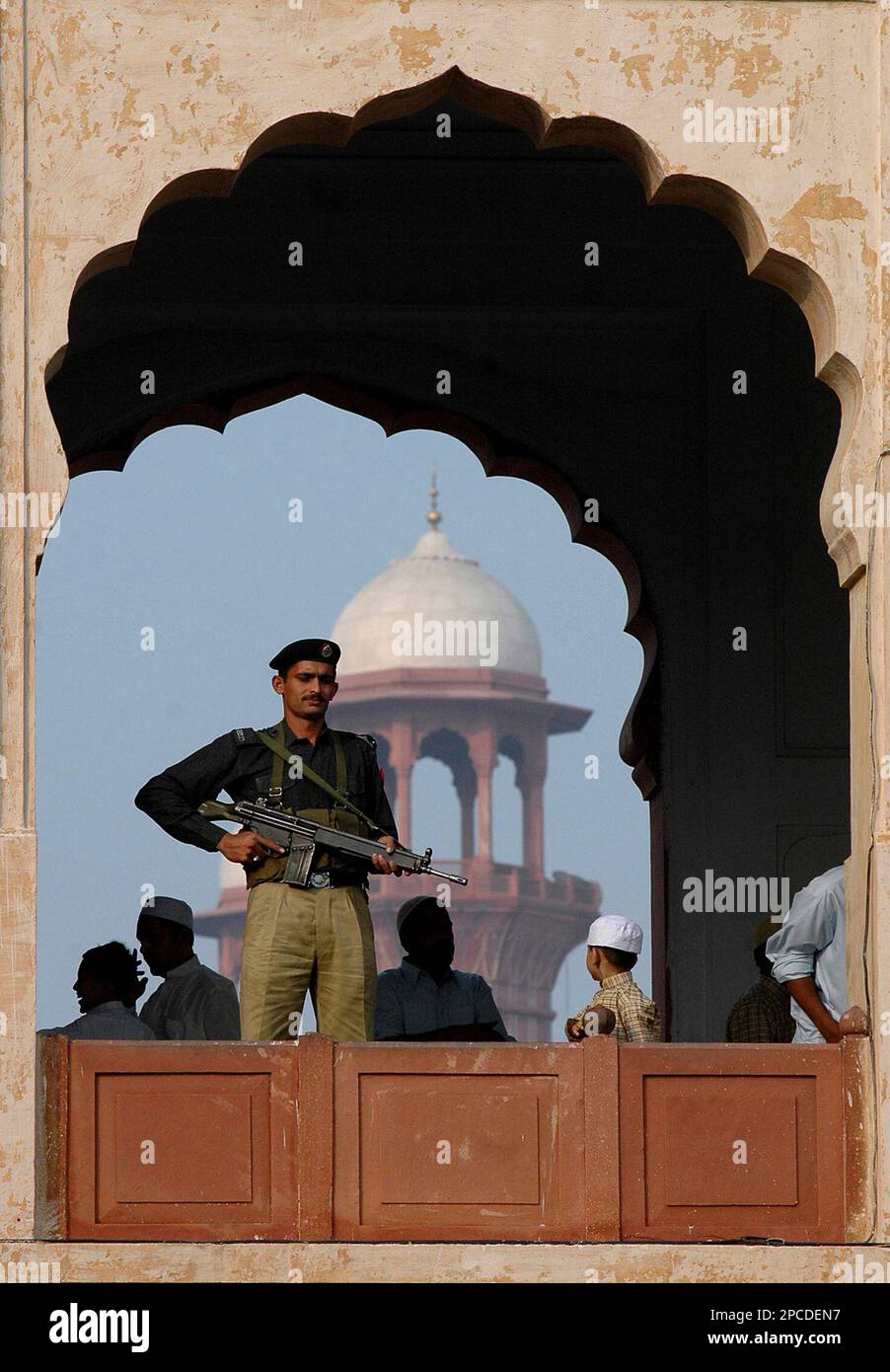 A Pakistani police officer stands guard at a balcony of historical ...