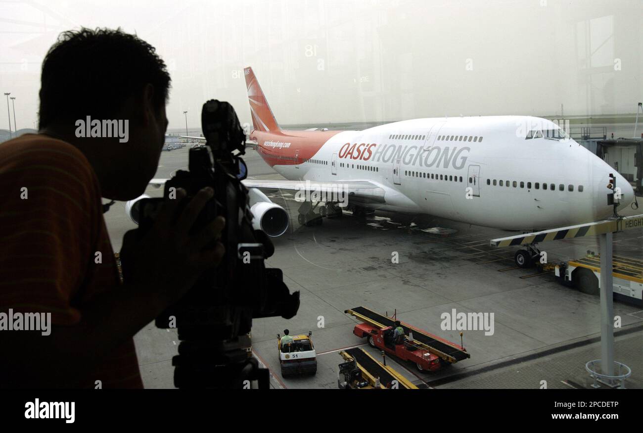A TV camera man film an Oasis Hong Kong Airlines plane on the tarmac of ...