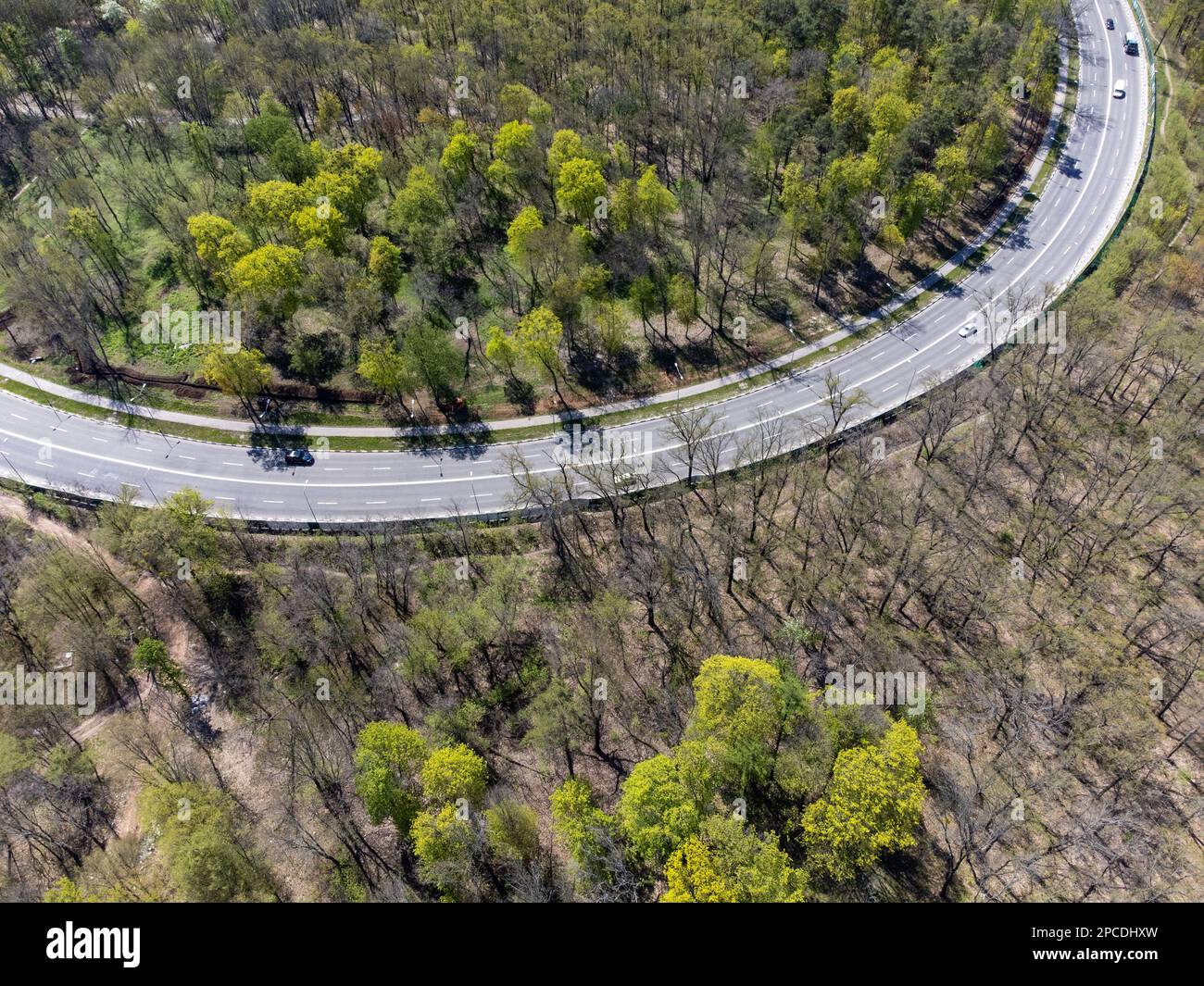 Aerial look down view highway road curve surrounded in forest with ...