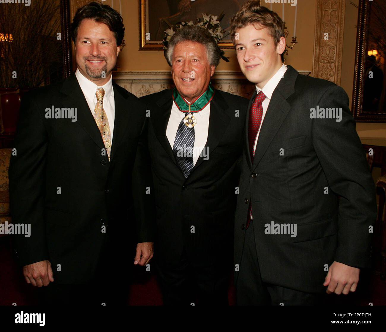 Race car driver Mario Andretti is flanked by his son, Michael, left ...