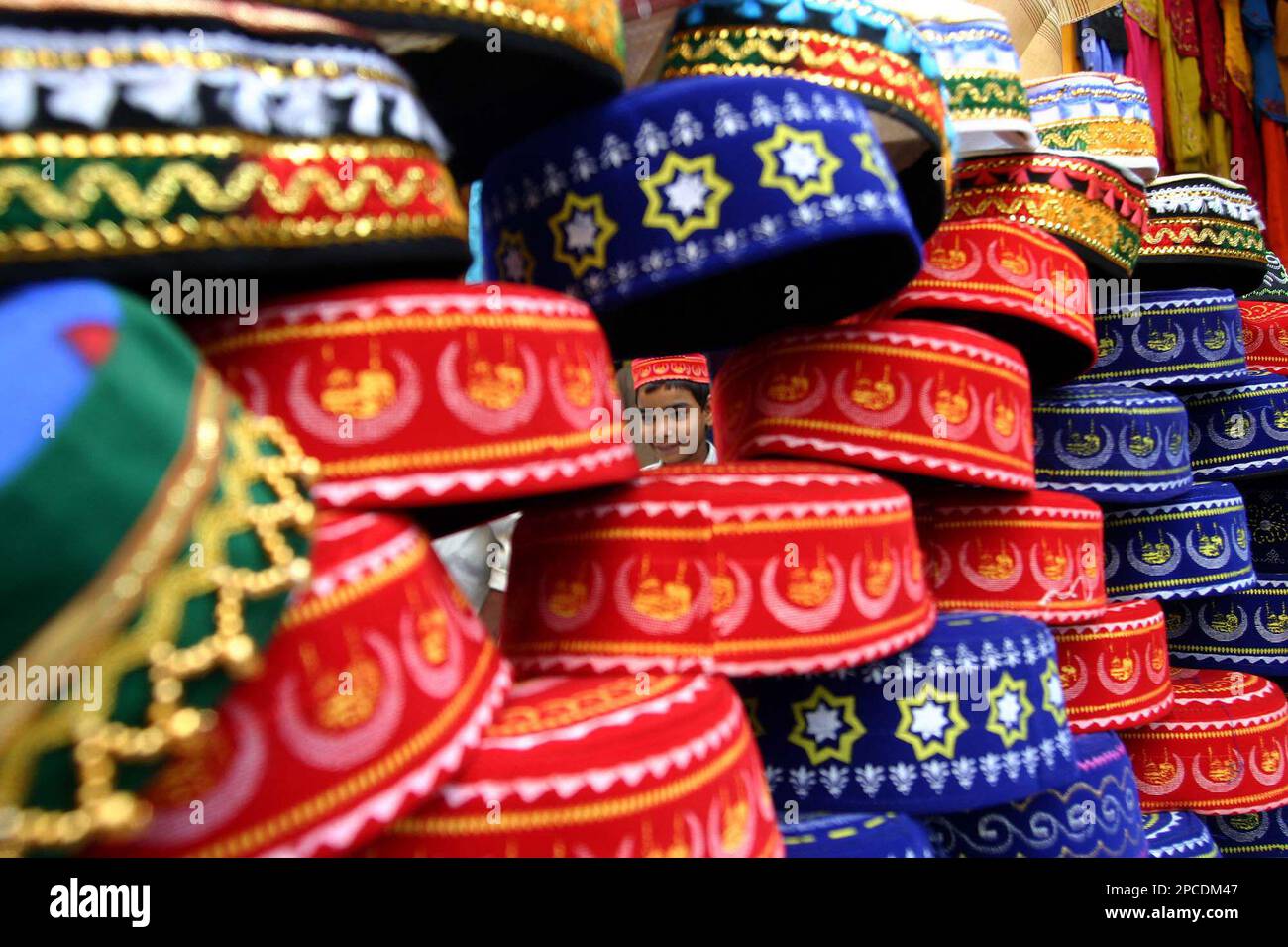 An Indian Muslim boy sells colorful caps ahead of Eid-ul-Fitr festival ...
