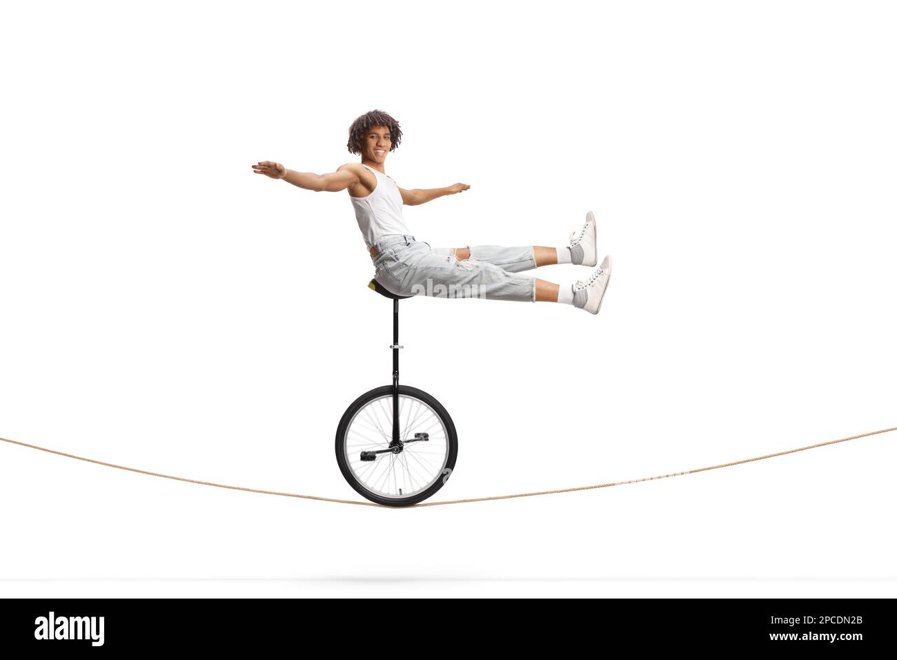 African american male acrobat sitting on a monocycle over a rope ...