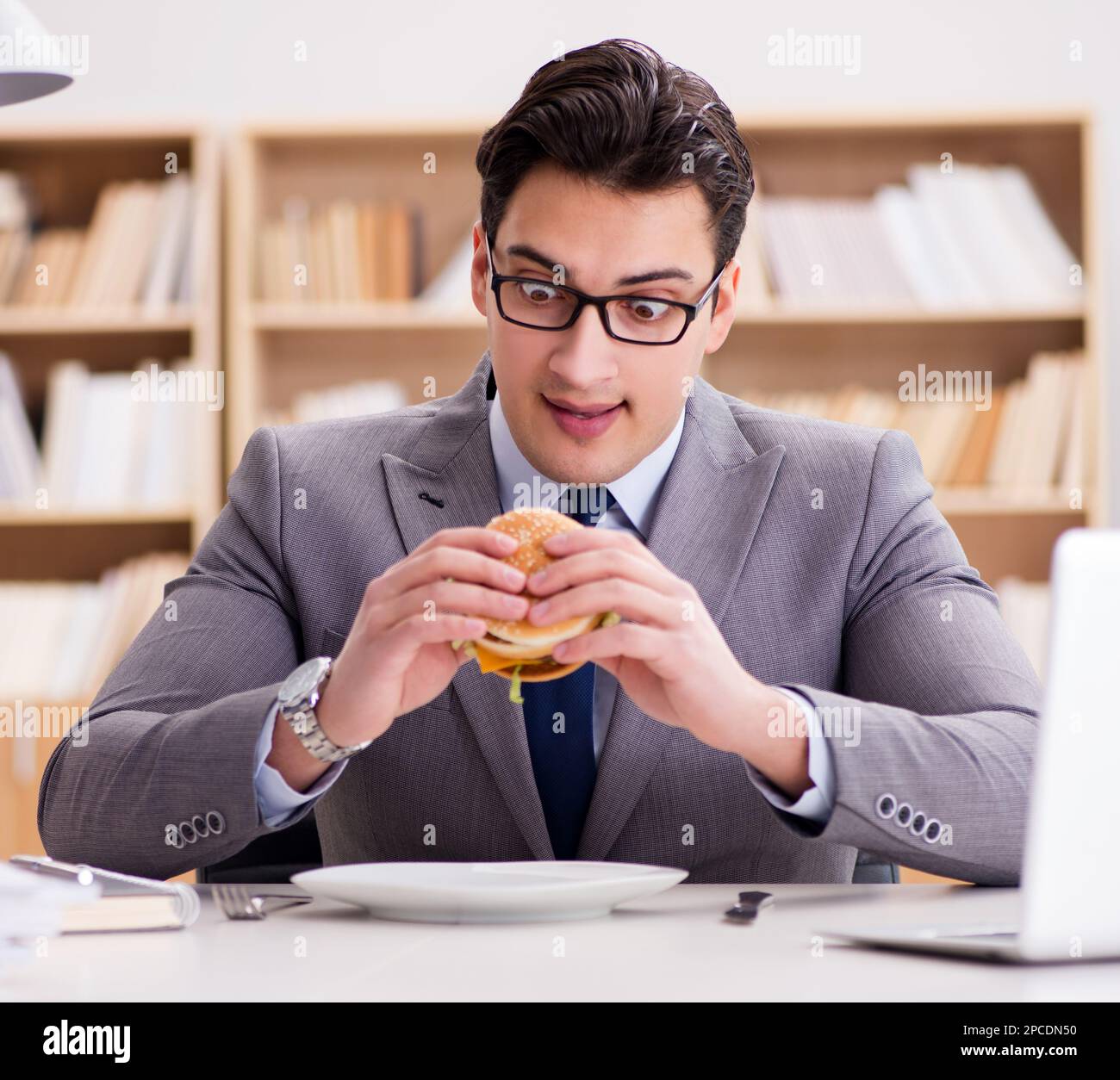 The hungry funny businessman eating junk food sandwich Stock Photo - Alamy