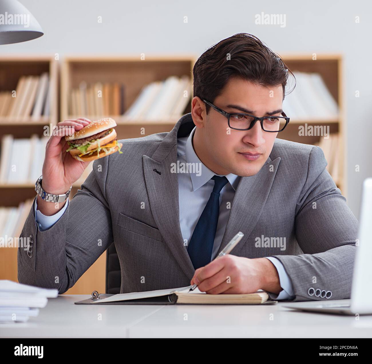 The hungry funny businessman eating junk food sandwich Stock Photo - Alamy