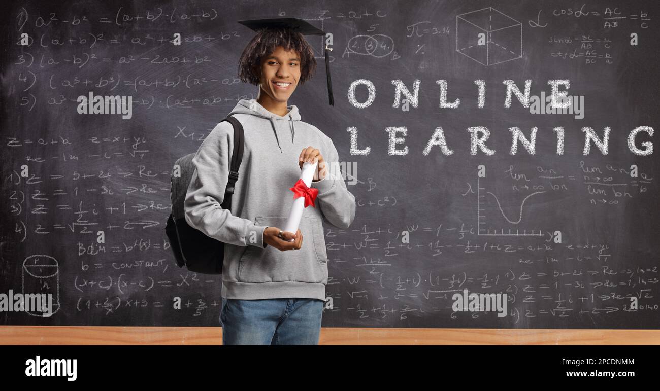 African american male student holding a diploma and posing in front of ...