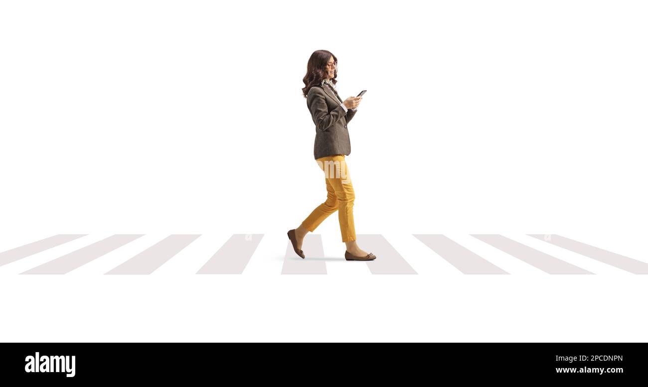 Young woman with a smartphone walking on a pedestrian crossing isolated ...