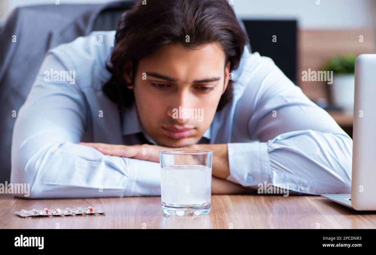 The sick male employee suffering in the office Stock Photo - Alamy