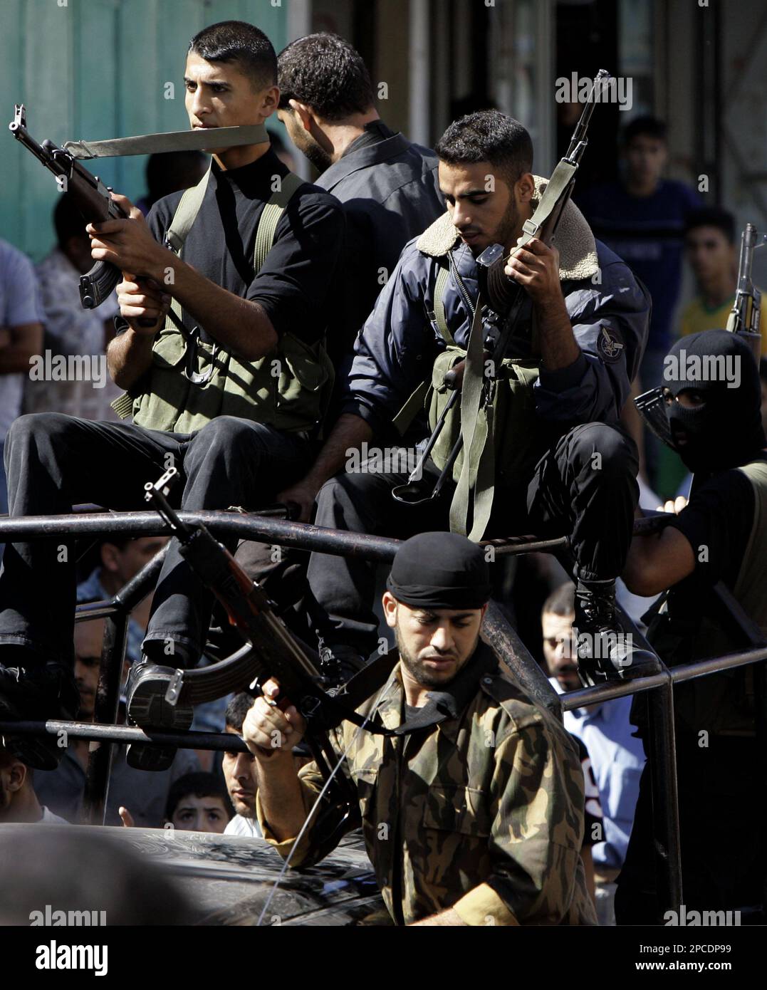 Palestinian gunmen carry their weapons during the funeral of Al Aqsa ...