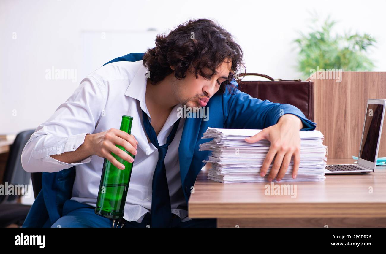 The young drunk employee in the office Stock Photo - Alamy
