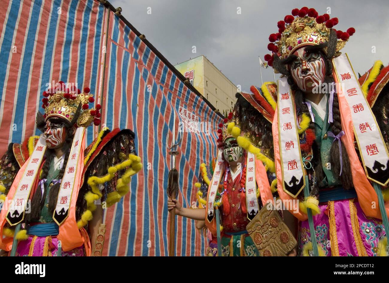 Worshippers dressed as generals of the Chinese mythology look on during ...