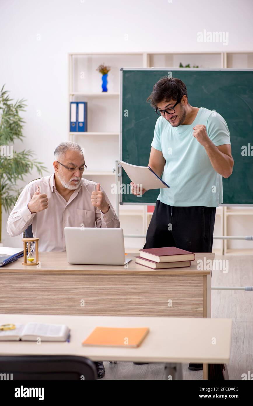 Old teacher and young student in the classroom Stock Photo - Alamy