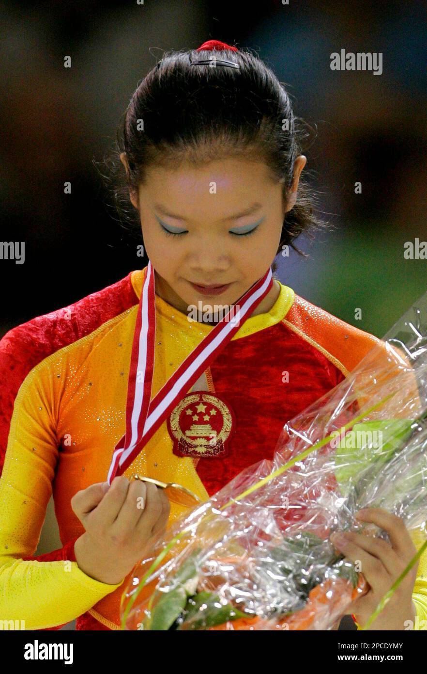 Gold medalist China's Cheng Fei looks at her medal as she stands on the ...