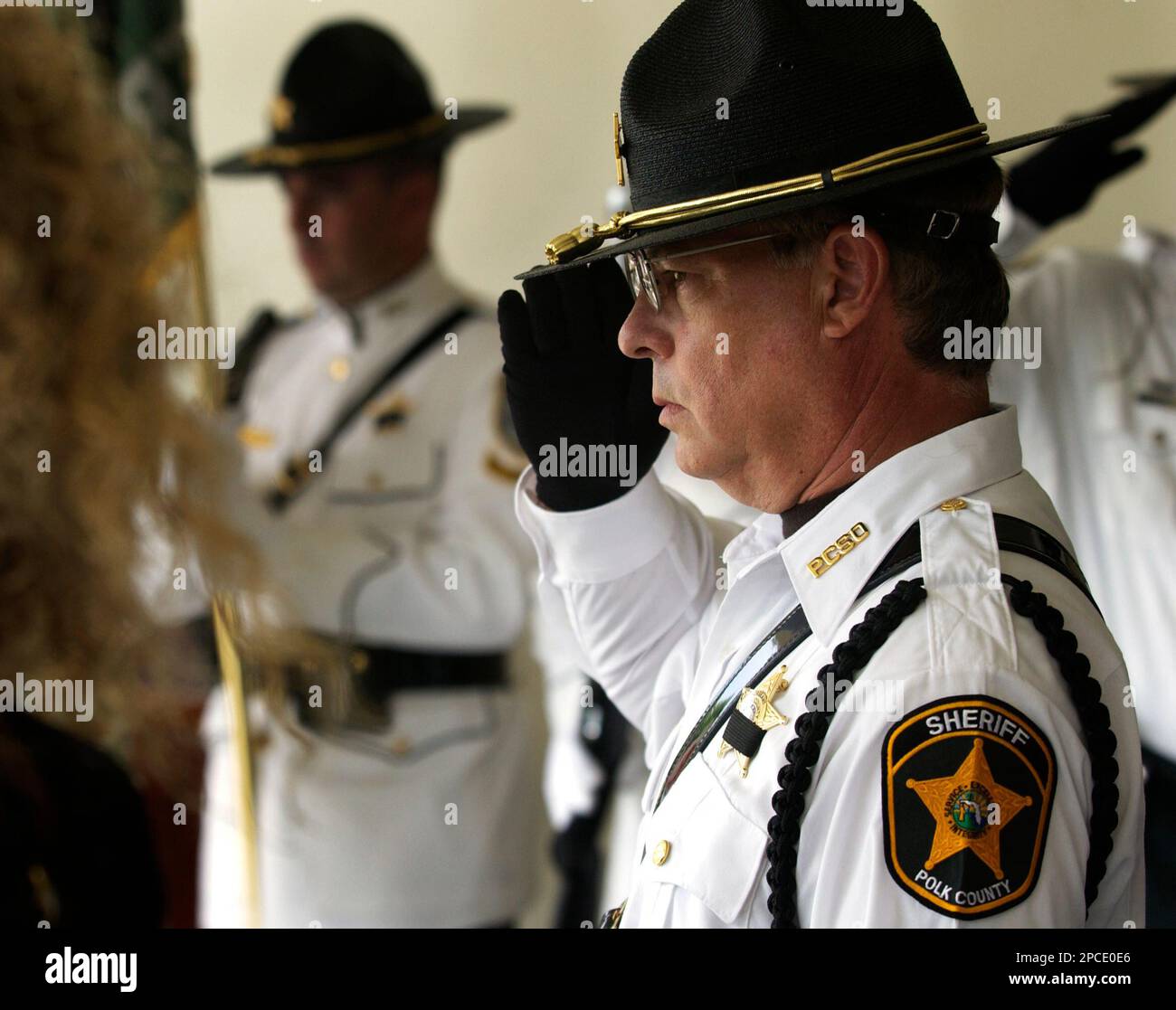 A Polk County Sheriff's Office honor guard salutes the family of fallen ...