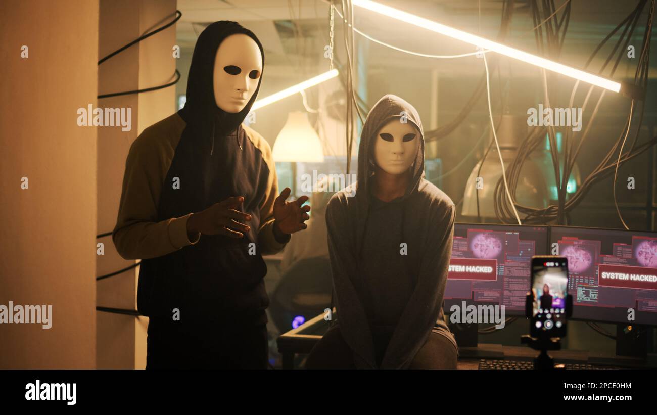 Cyber criminals wearing anonymous masks broadcasting video to make ...