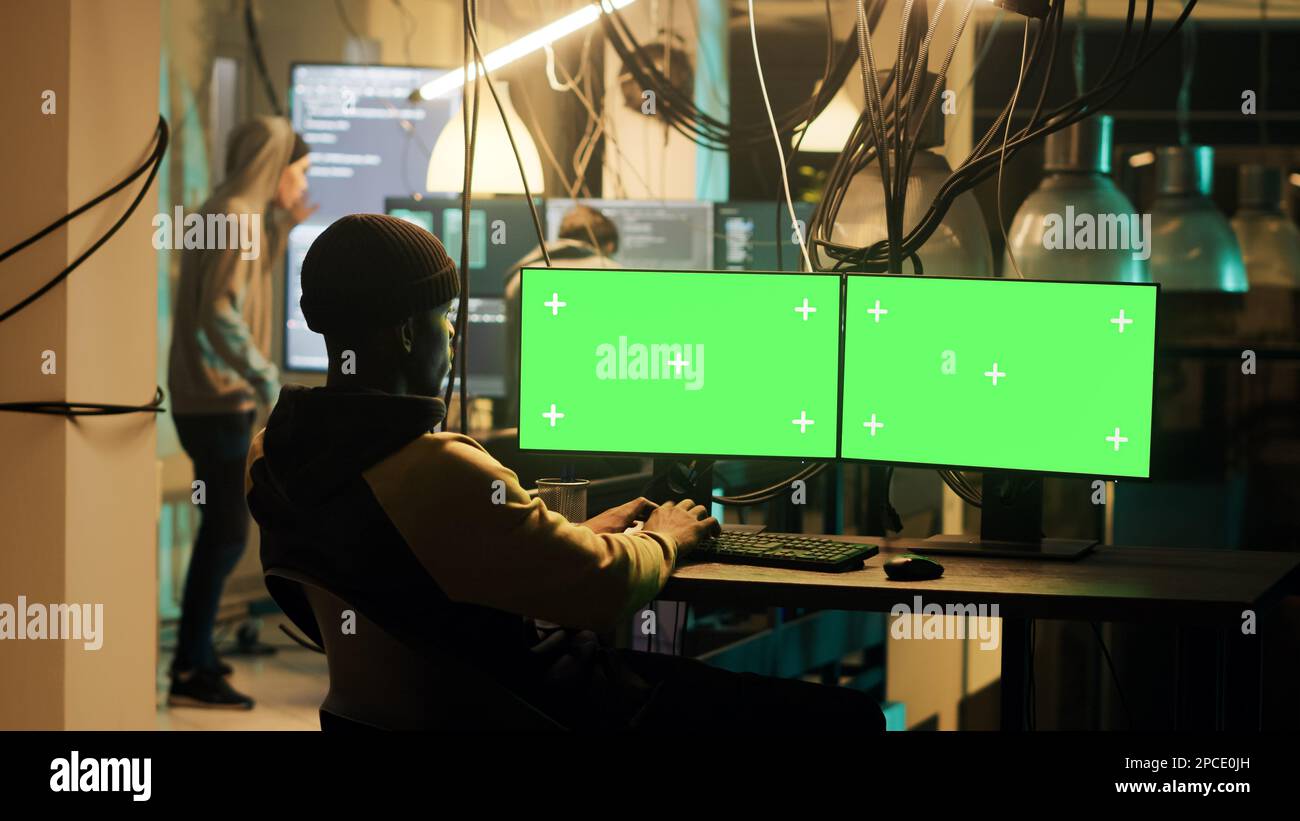Hacker checking computer display with greenscreen while stealing ...
