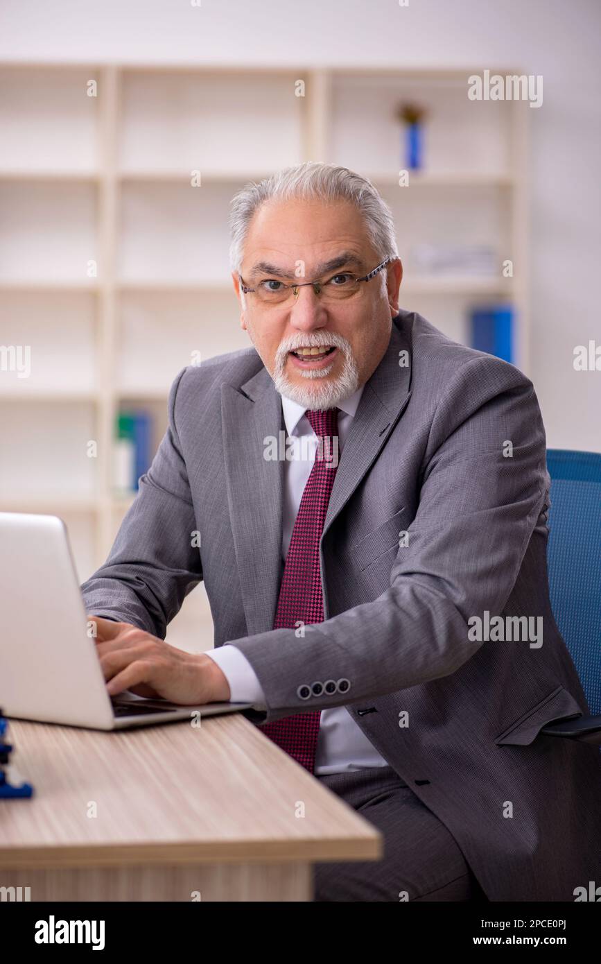 Old boss employee sitting at workplace Stock Photo - Alamy