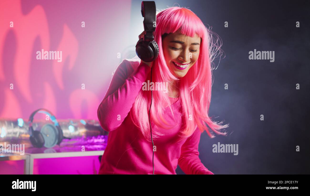 Smiling dj performing electronic music at party in nightclub, enjoying ...