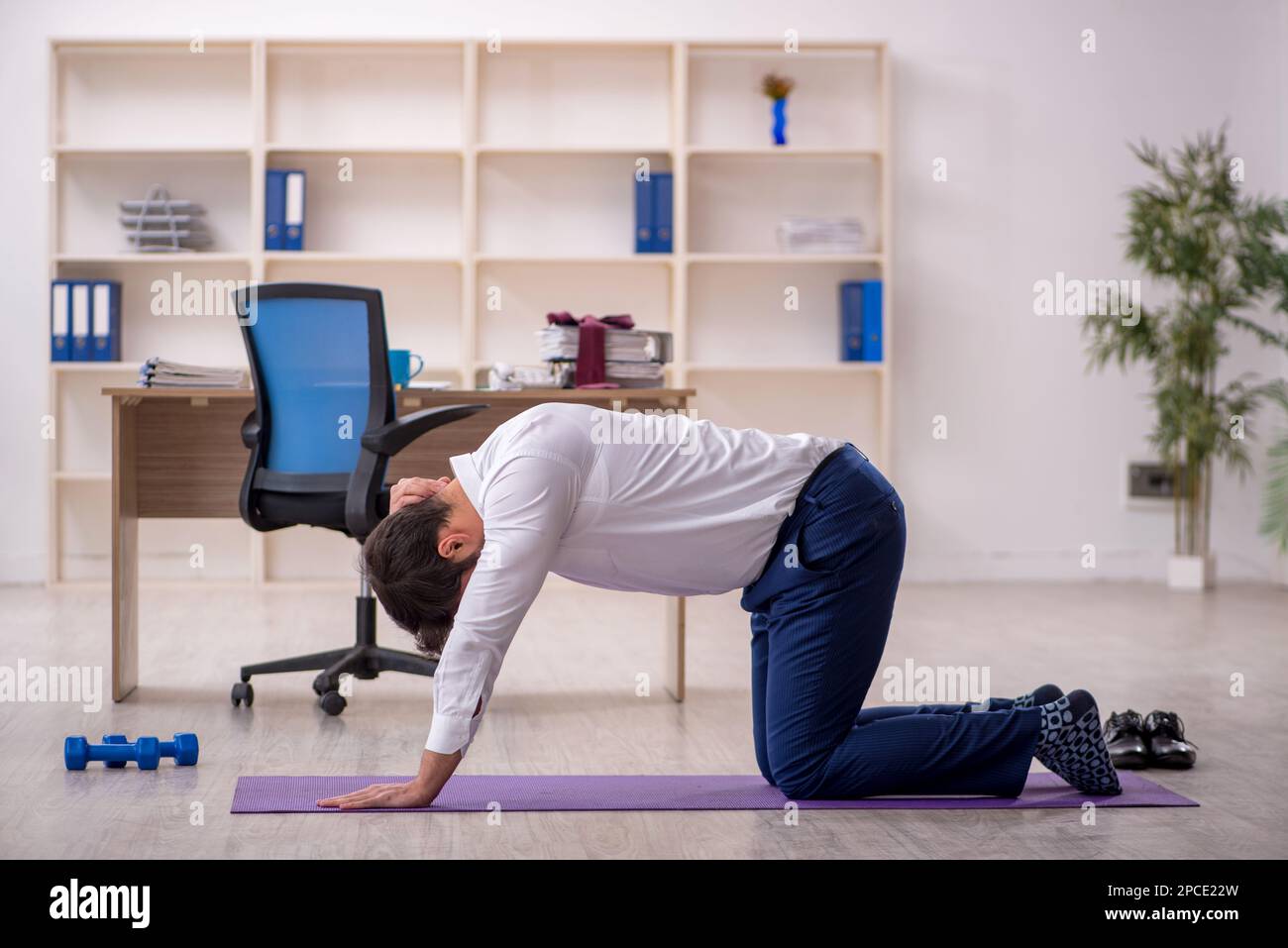 Young employee doing sport exercises during break Stock Photo - Alamy