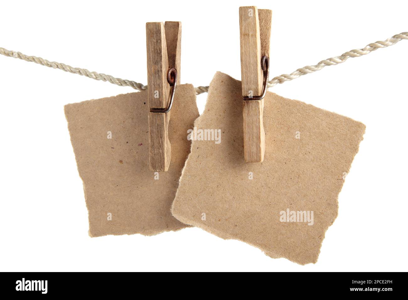 Craft note paper pinned with a vintage clothespin on a rope on a white ...