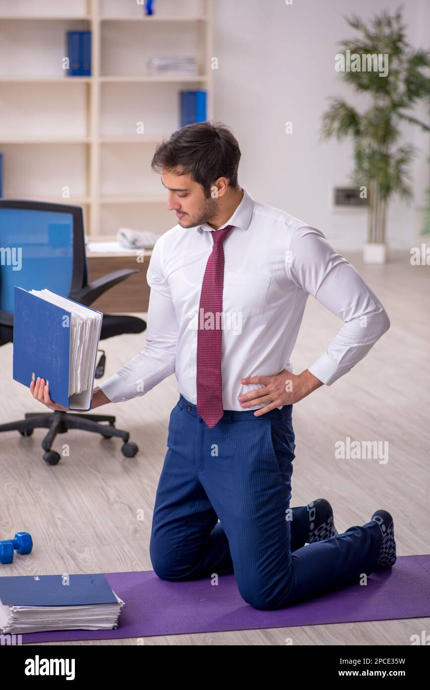Young employee doing sport exercises during break Stock Photo - Alamy
