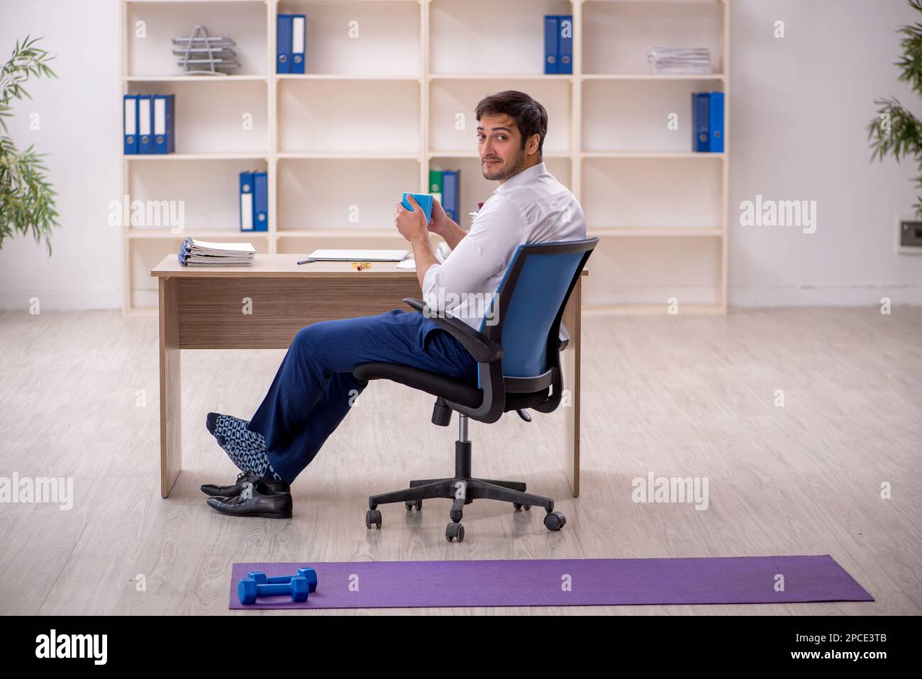 Young employee doing sport exercises during break Stock Photo - Alamy