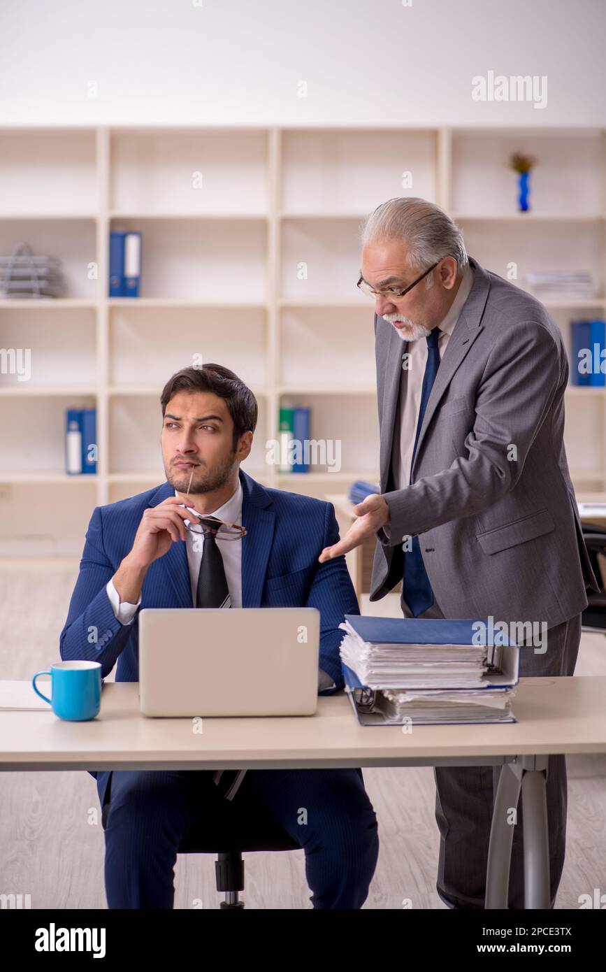 Old boss and young employee in the office Stock Photo - Alamy