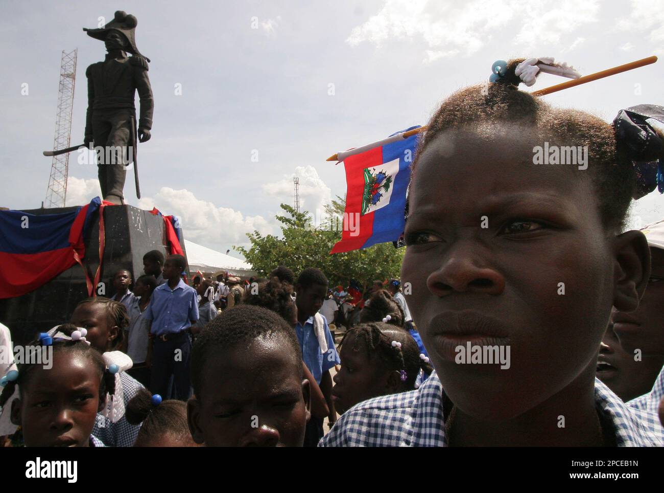 A student with a Haitian flag in her hair attends a ceremony to ...