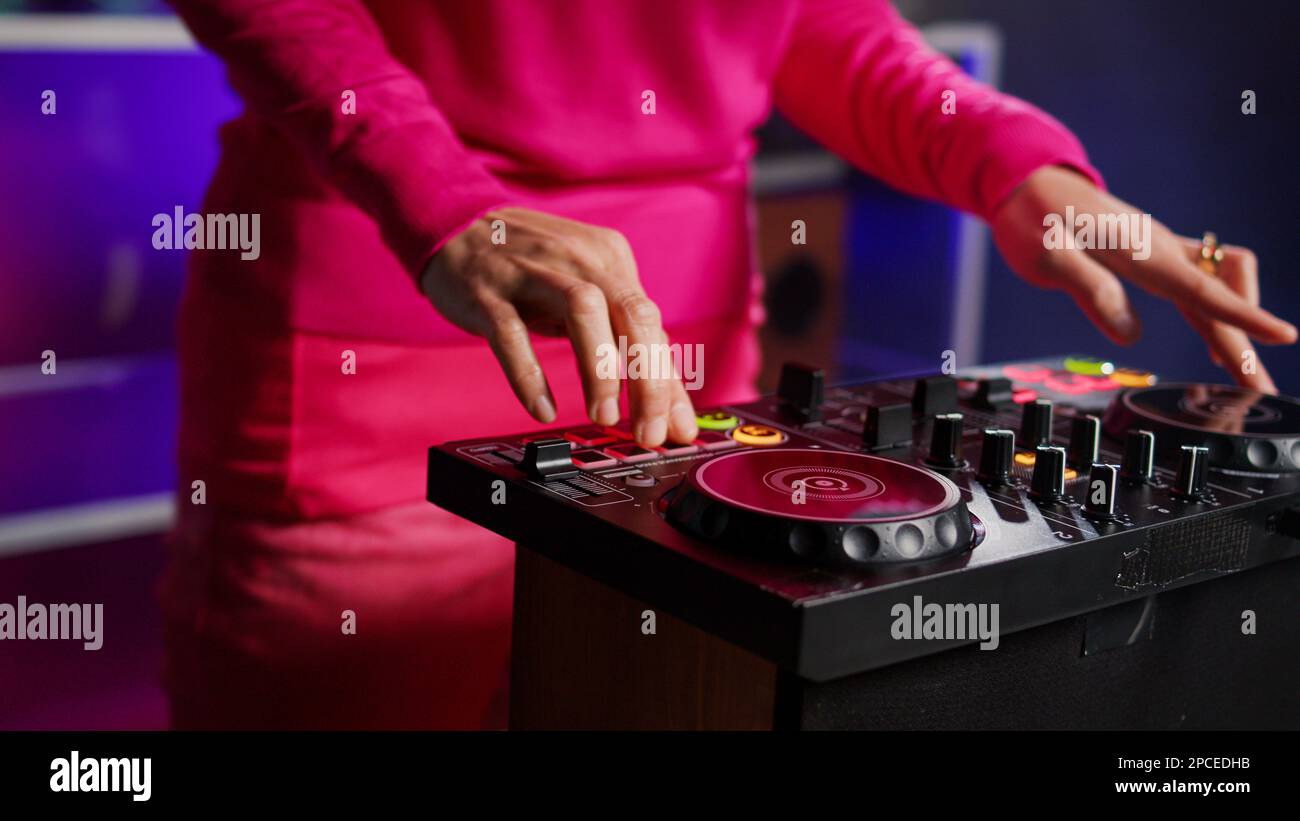 Artist standing at dj table mixing sound using mixer console ...
