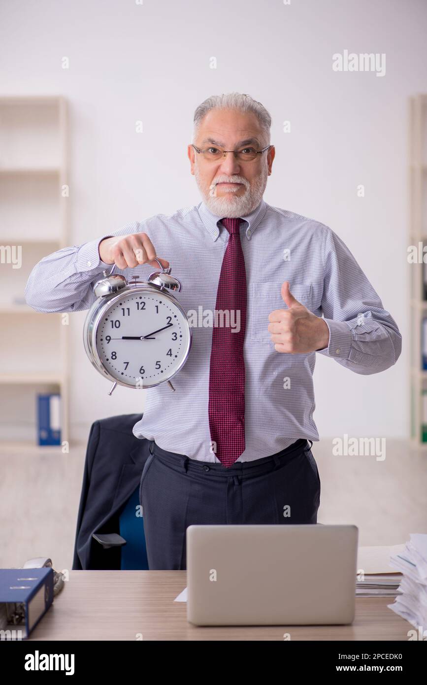 Old boss employee in time management concept Stock Photo - Alamy