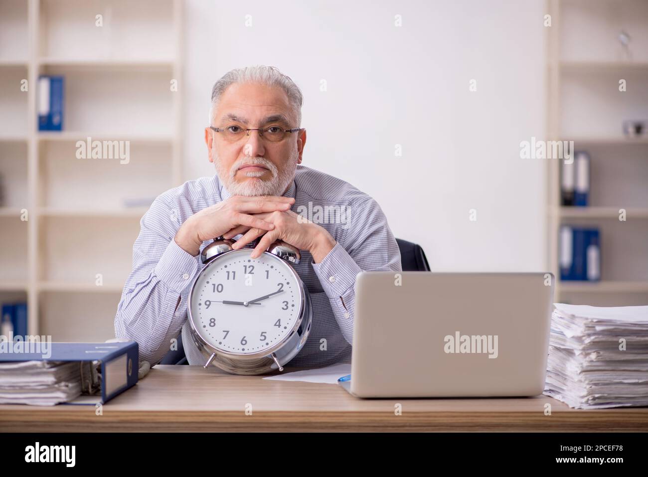 Old boss employee in time management concept Stock Photo - Alamy